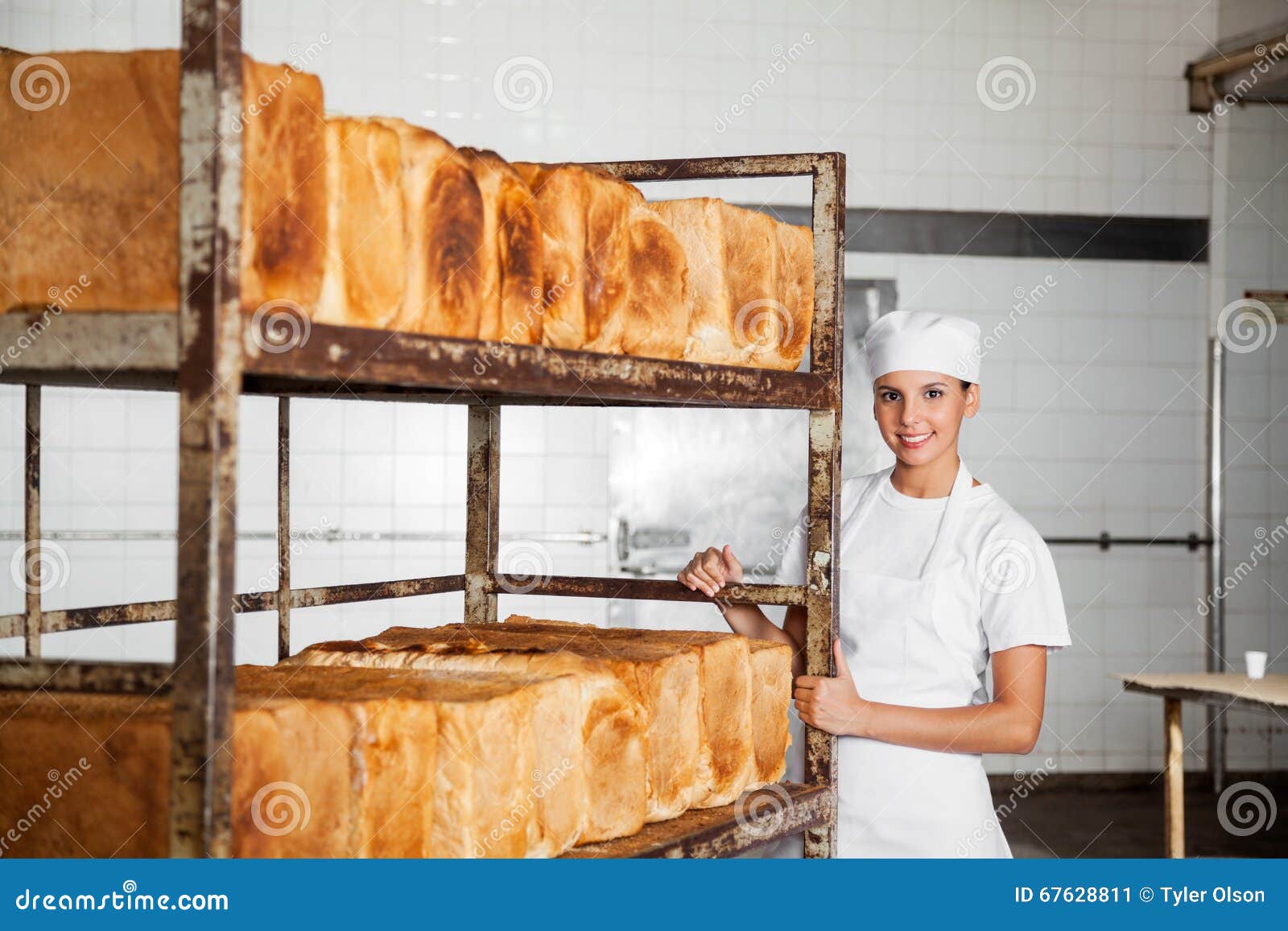 Vrouwelijk Baker Standing by Rack Met Vers Gebakken Broden Stock ...