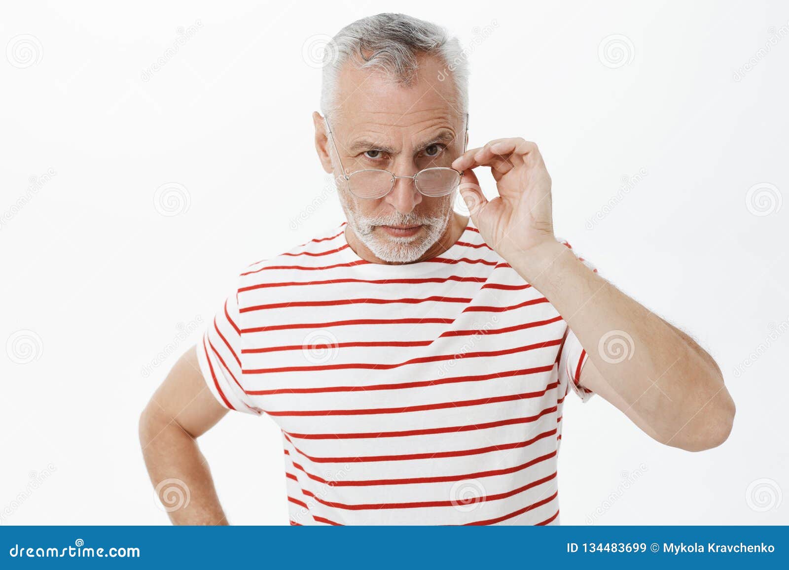 Waist Up Shot Of Serious Looking Suspicious Old Bearded Man With Grey