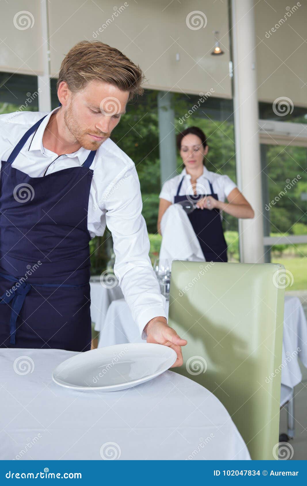 Waiter Arranging Place Settings on Table Stock Photo - Image of setting ...