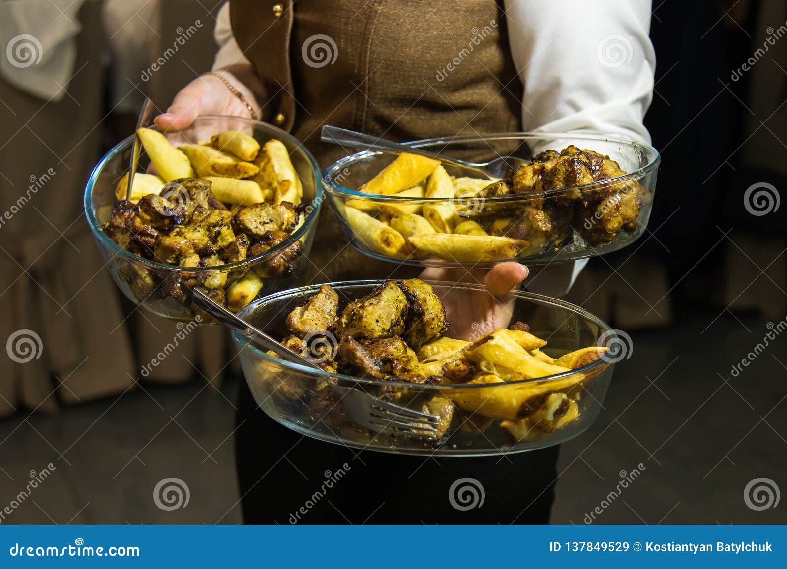 Waiter Carrying Three Plates with Meat Dish and Potatoes on Some ... Waiter Carrying Three Plates with Meat Dish and Potatoes on Some ...