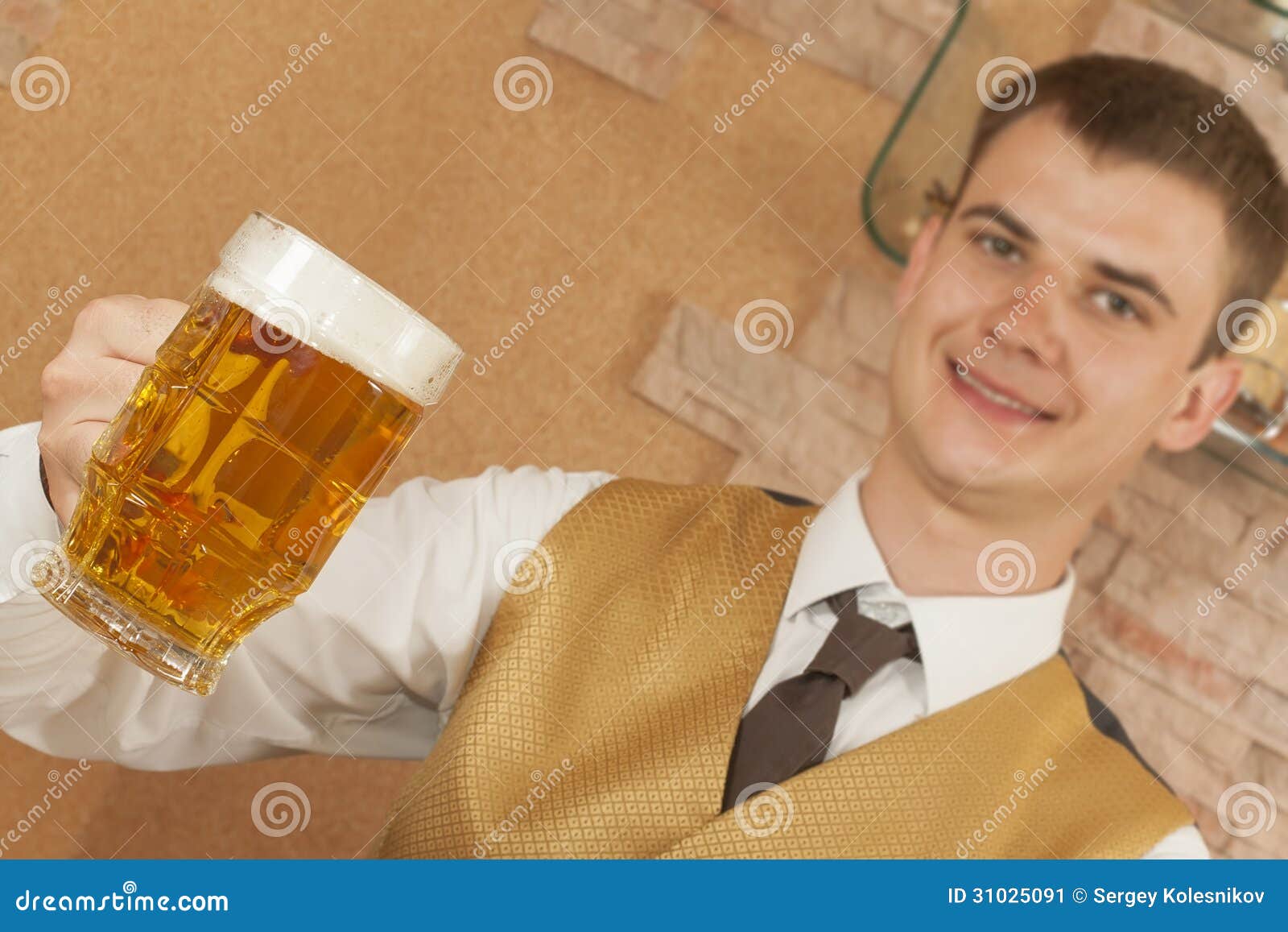 Waiter holds glass of beer stock image. Image of light - 31025091