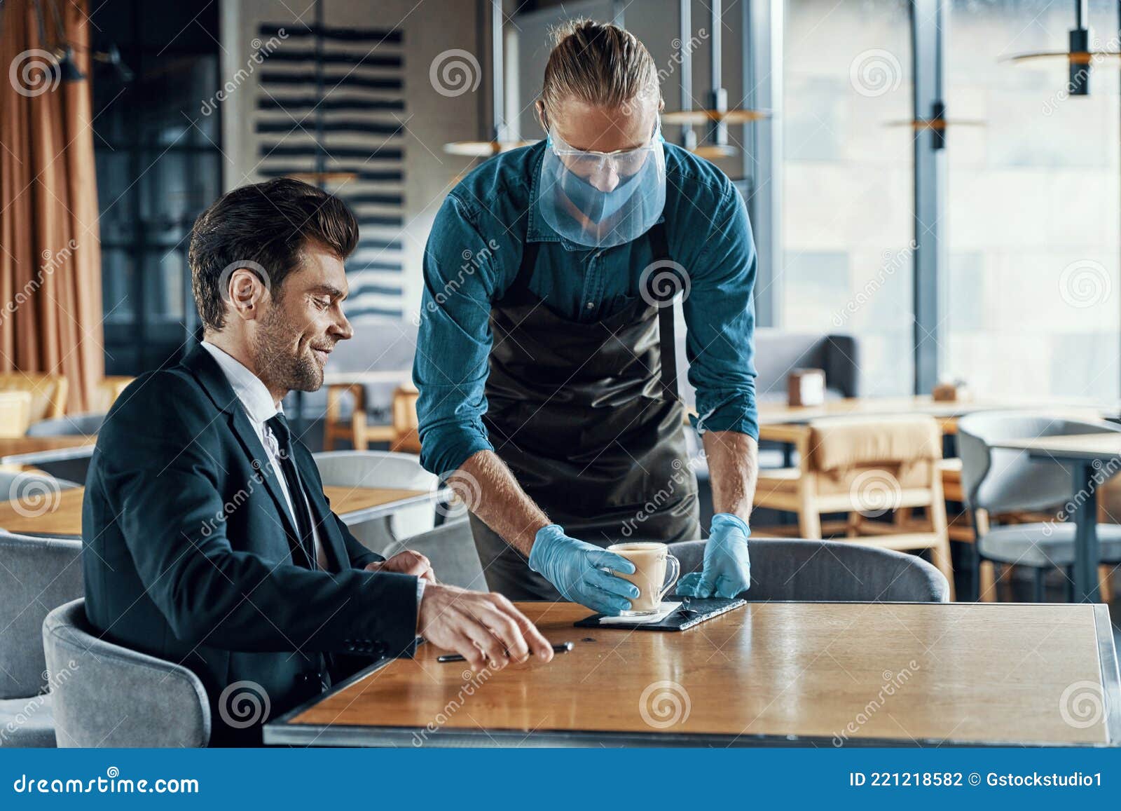 Waiter in Protective Face Shield Bringing Client a Cup of Coffee while ...