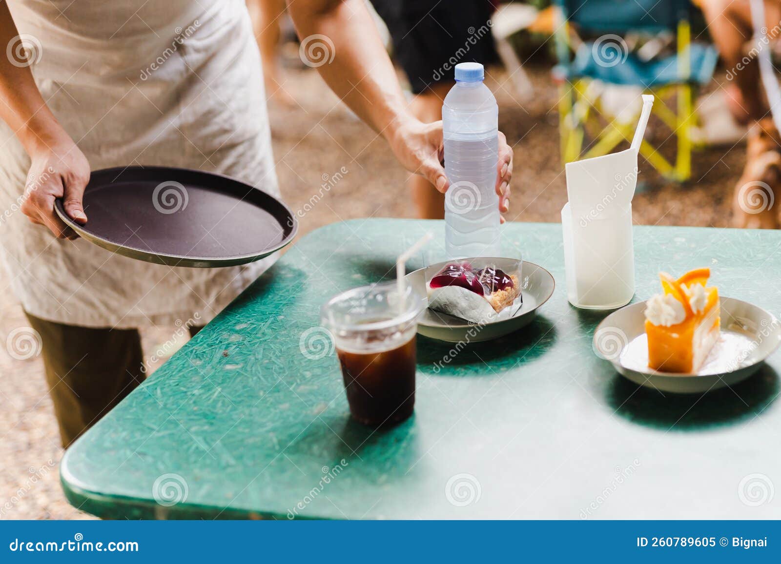 Waiter Serving a Bottle of Water on Table in Cafe Outdoor. Stock Image ...