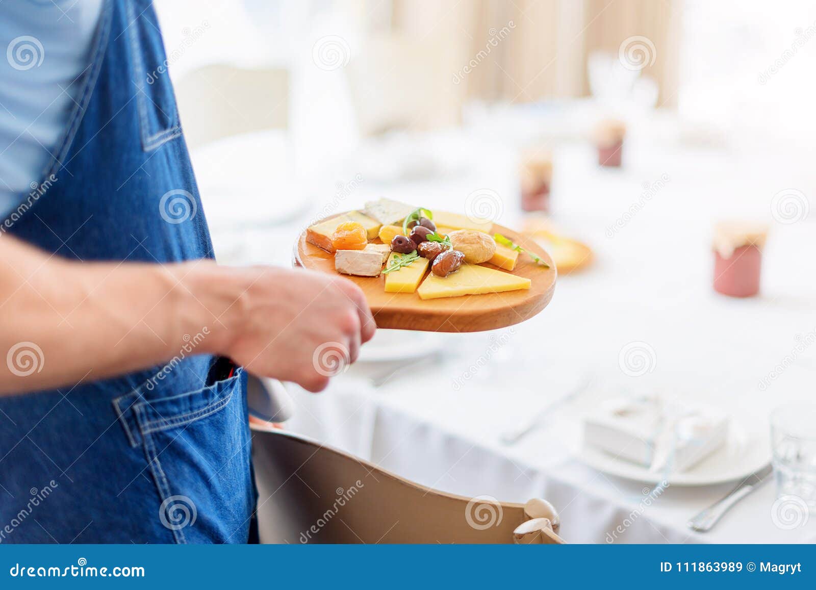Waiter Serving Olives and Cheese on Wooden Board. Stock Image - Image ...