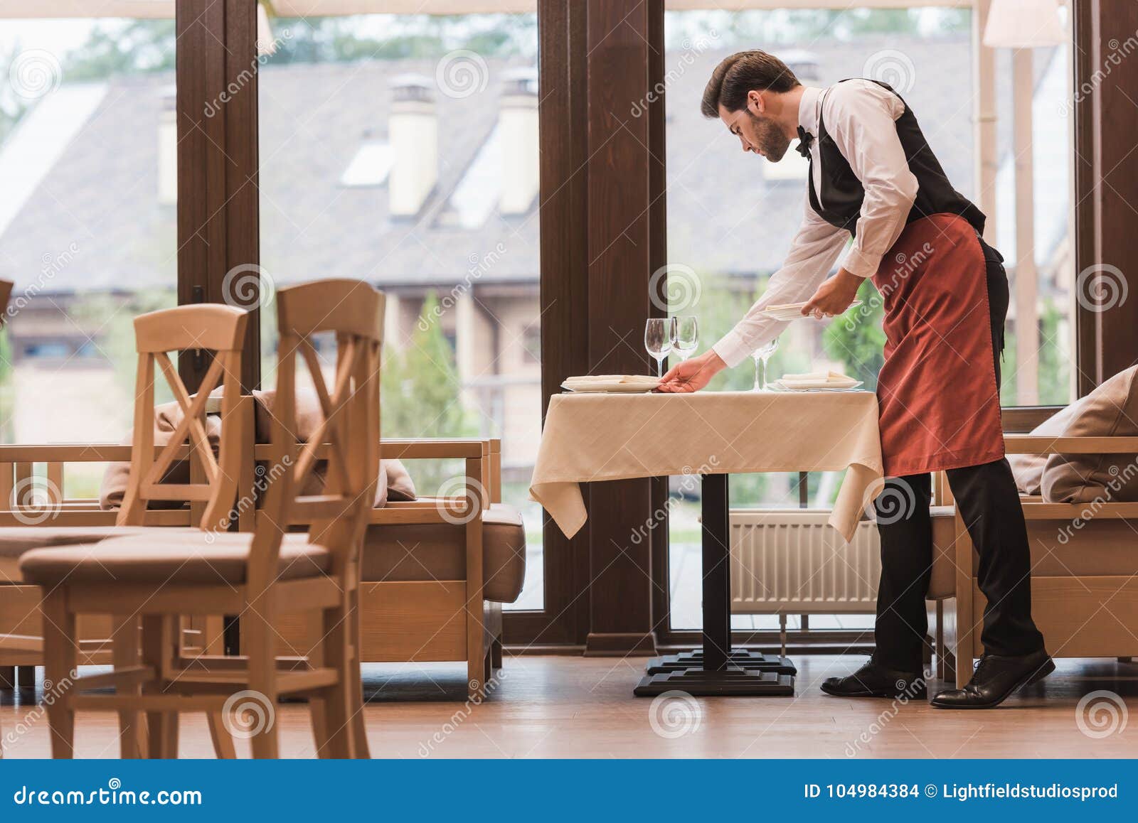 Waiter Serving Plates on Table Stock Photo - Image of brown, table ...