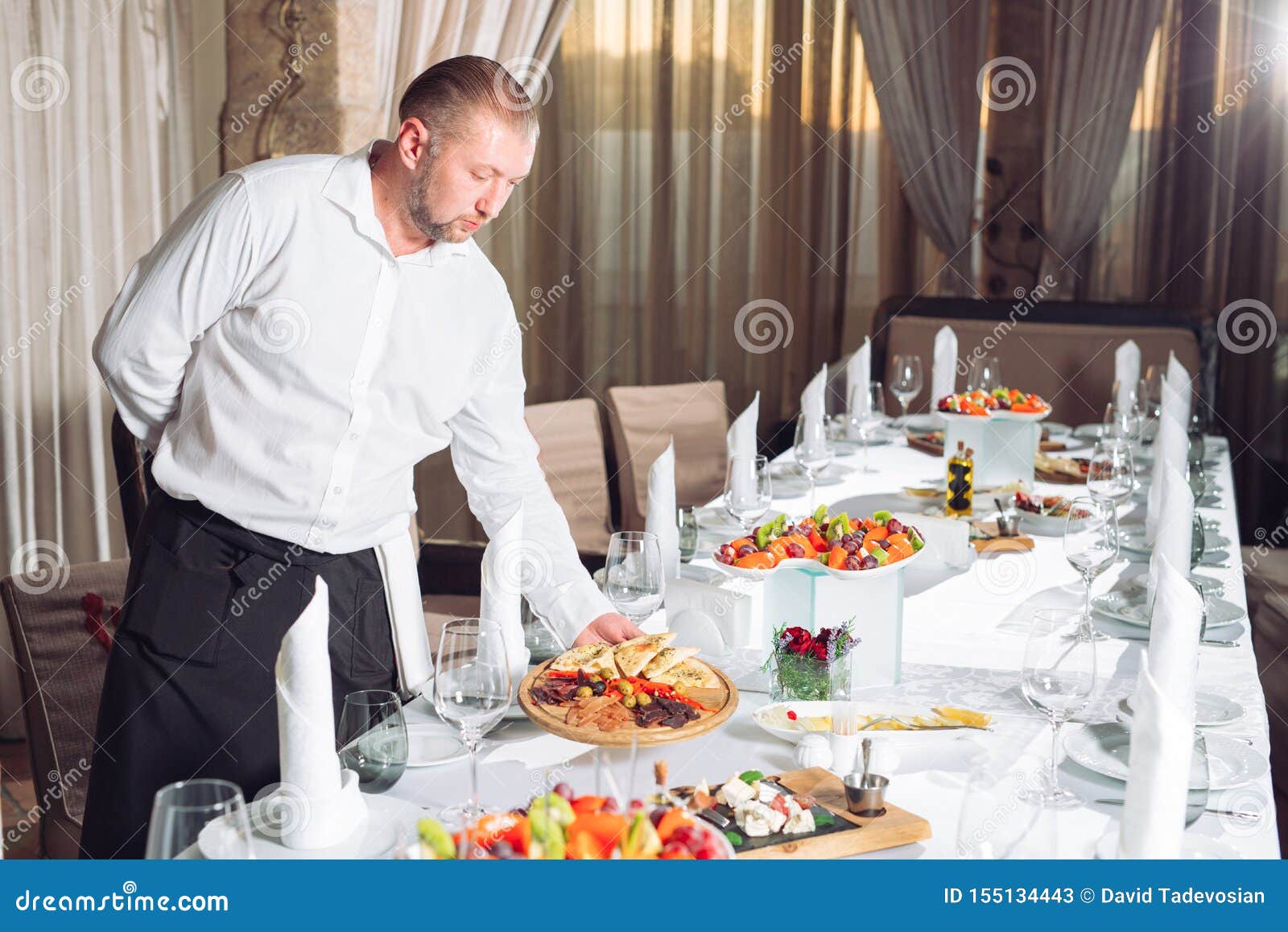 Waiter Serving Table in the Restaurant Preparing To Receive Guests ...