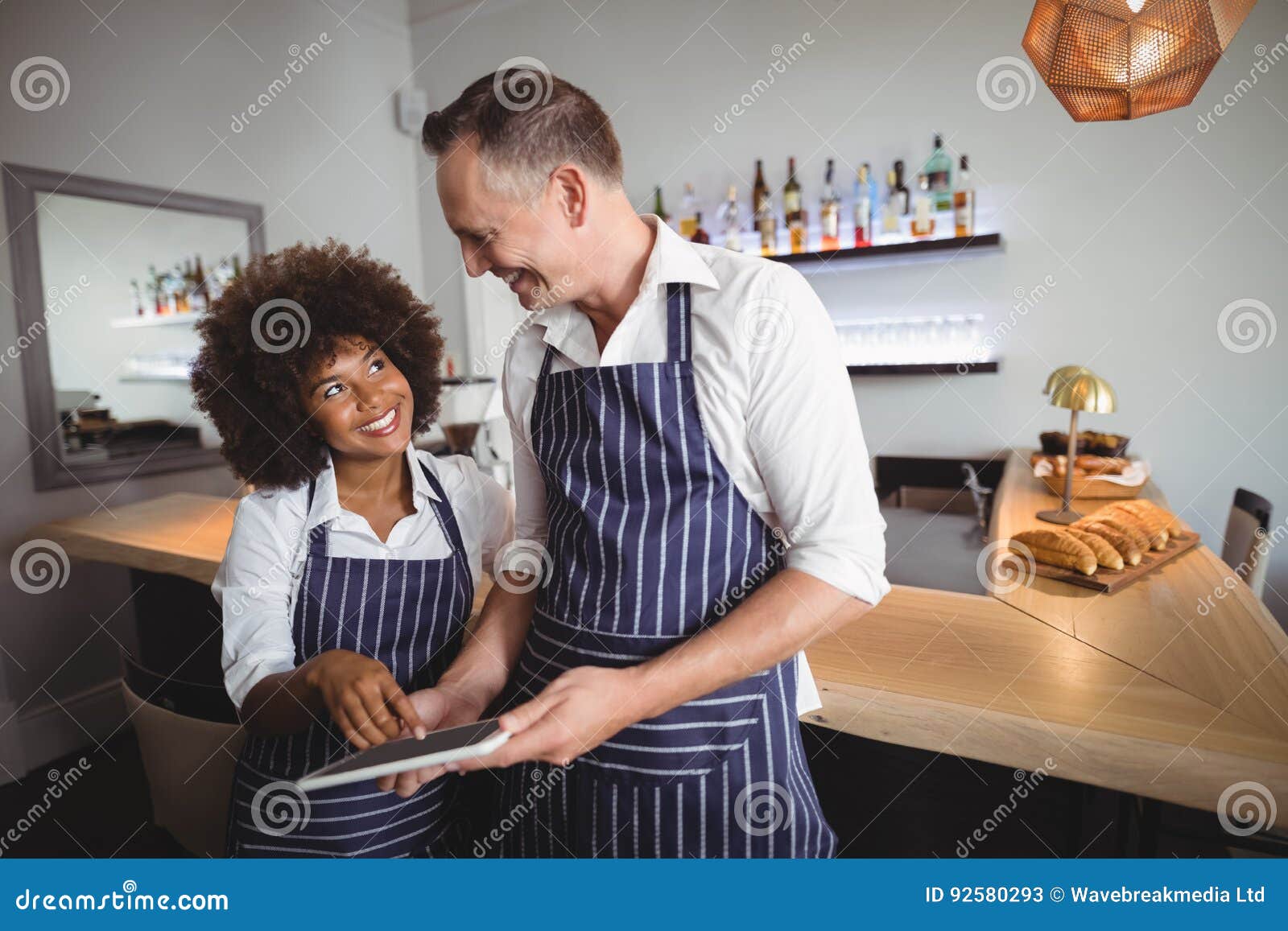 Waiter and Waitress Using Digital Tablet at Counter Stock Image - Image ...