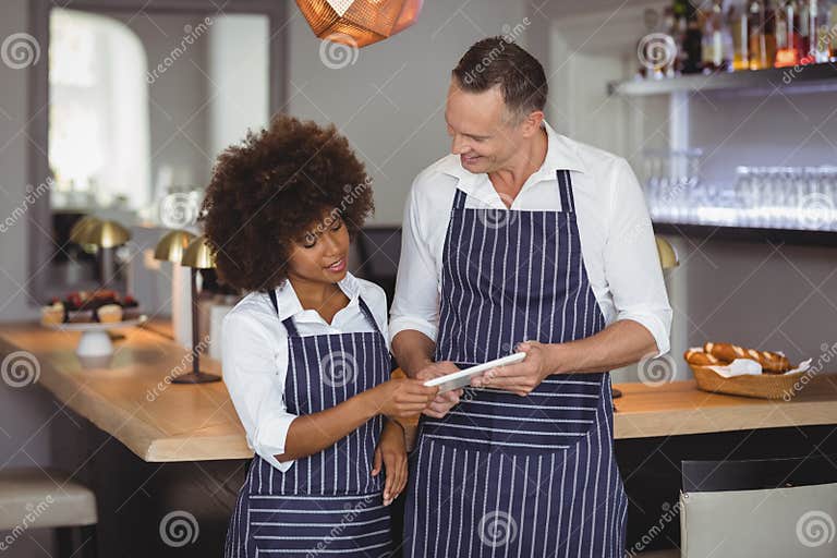 Waiter and Waitress Using Digital Tablet at Counter Stock Image - Image ...