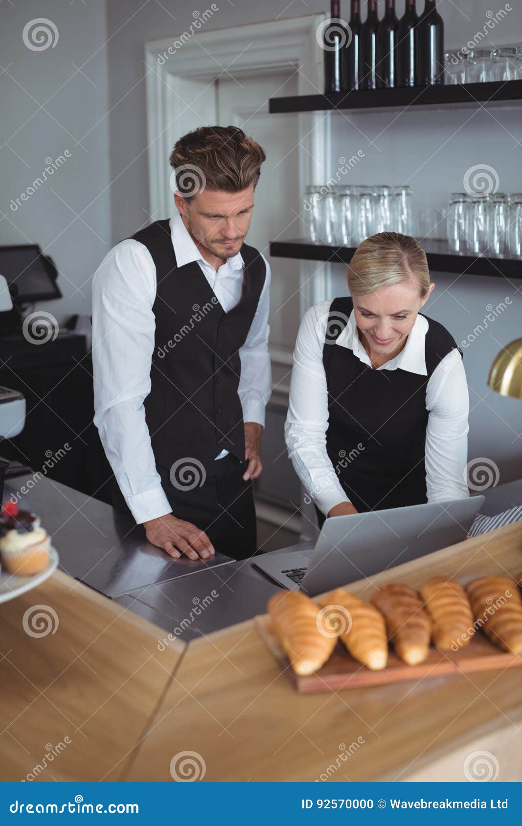 Waiter and Waitress Using Laptop at Counter Stock Photo - Image of ...