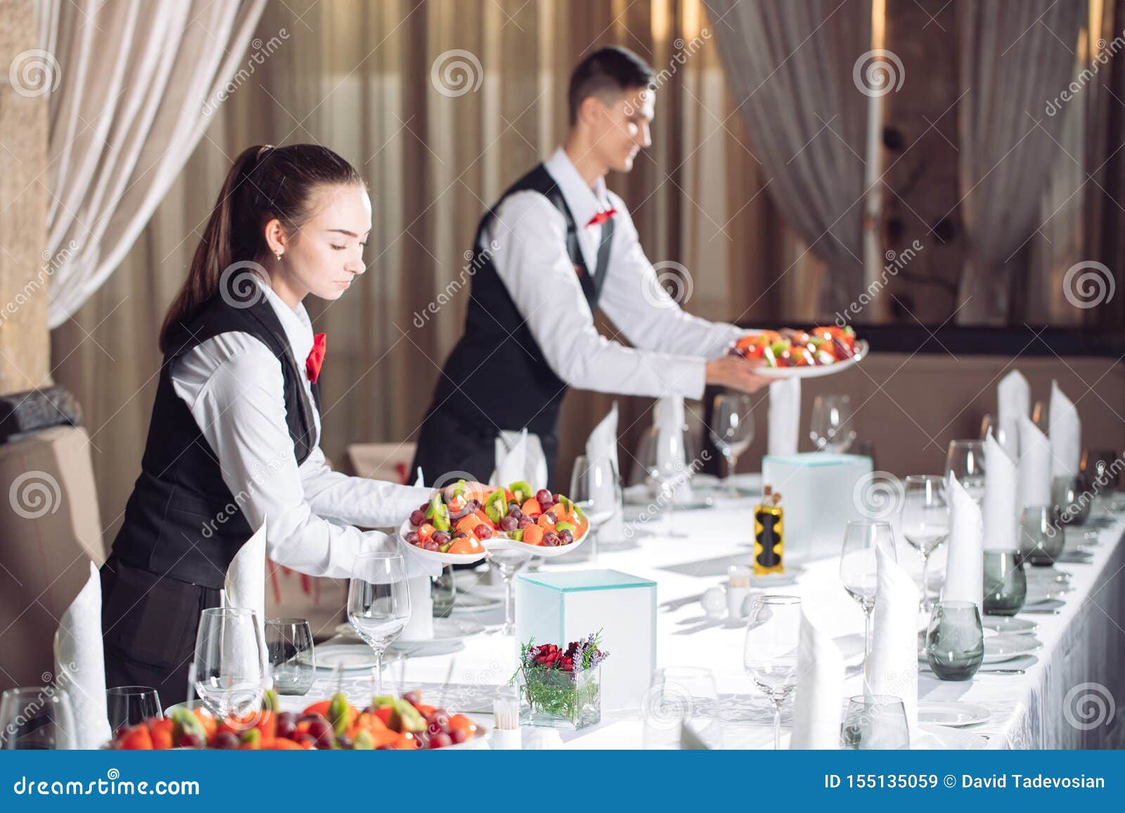 Waiters Serving Table in the Restaurant Preparing To Receive Guests ...