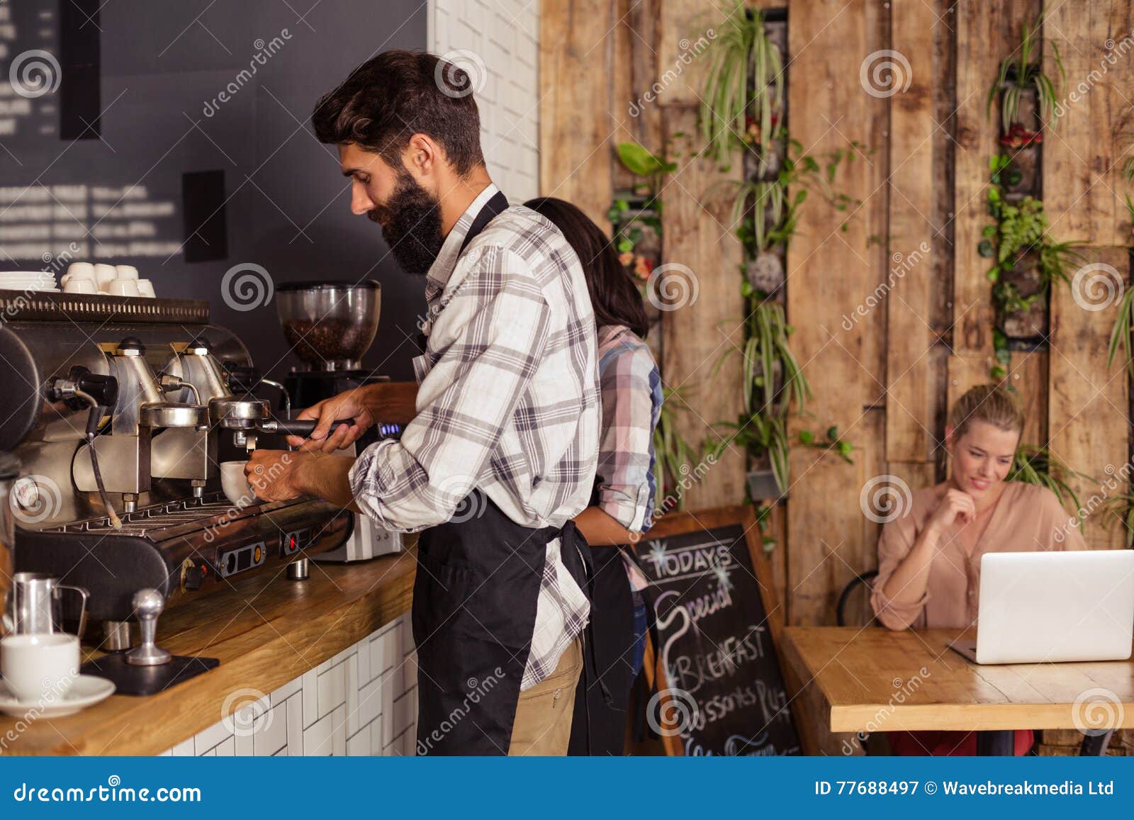 Waiters Using a Coffee Machine and Customer on a Laptop Stock Image ...