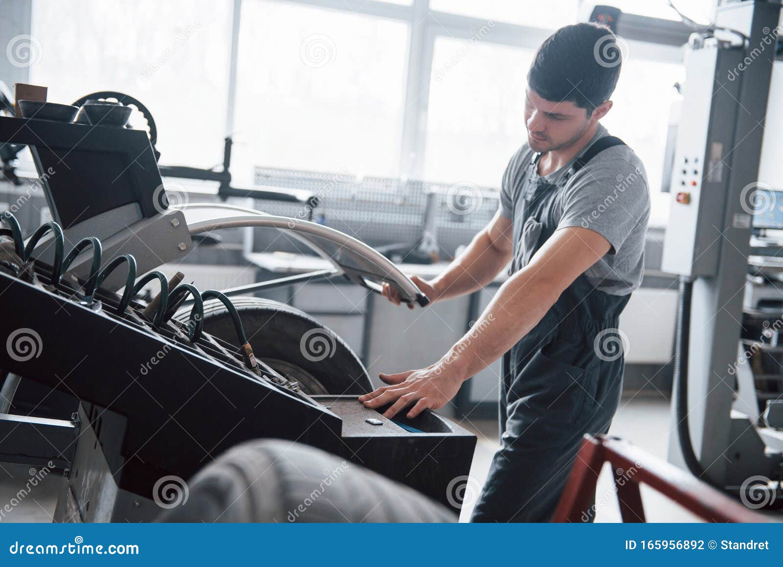 Waiting for Process is Done. Young Man Works with Wheel`s Disks at the ...