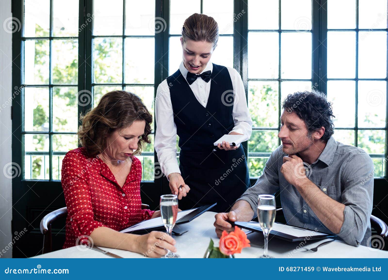 Waitress Assisting a Couple while Selecting Menu Stock Image - Image of ...