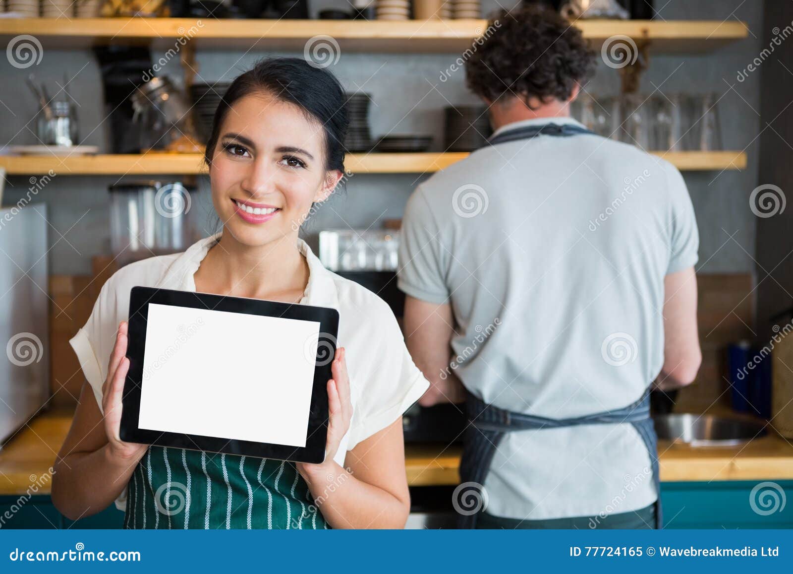 Waitress Holding Digital Tablet while Waiter Working in Background ...