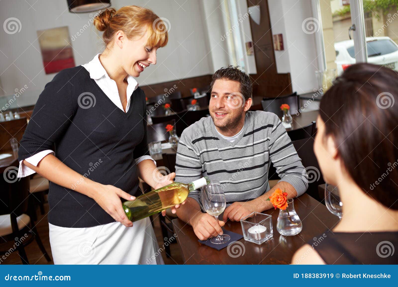 Waitress pours white wine stock image. Image of male - 188383919