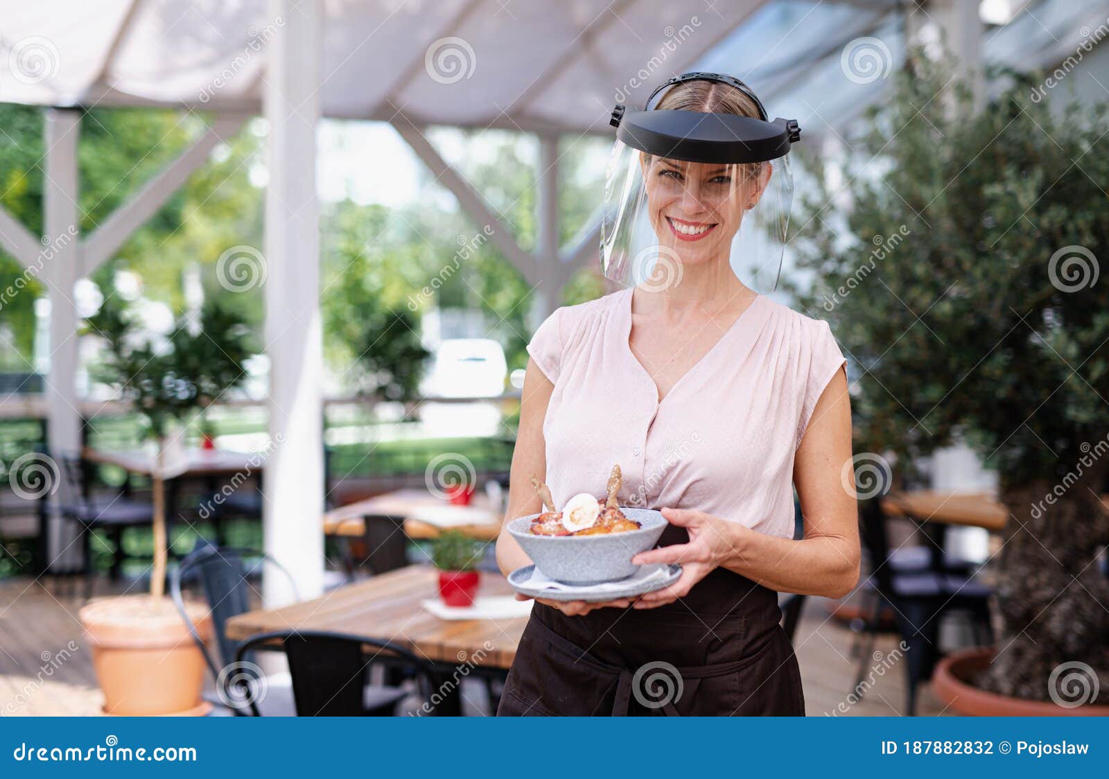 Waitress with Protective Face Shield Serving Customers Outdoors on ...