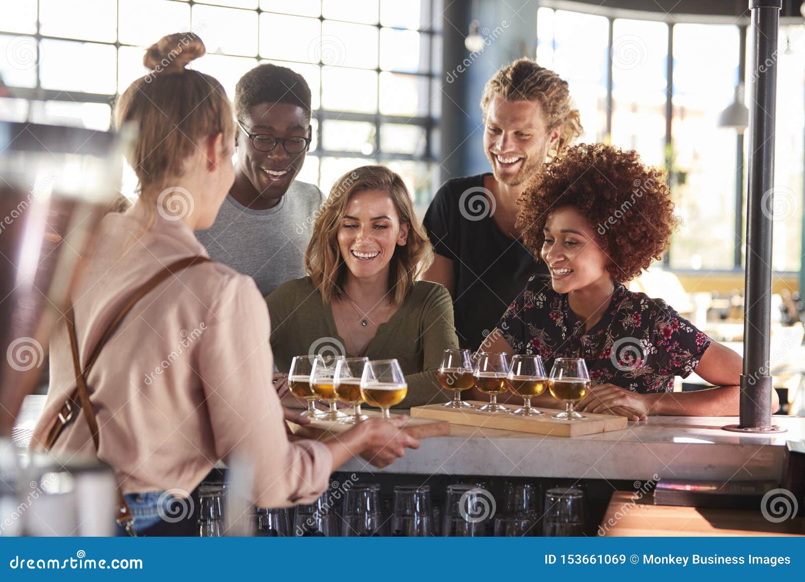Waitress Serving Group of Friends Beer Tasting in Bar Stock Image ...