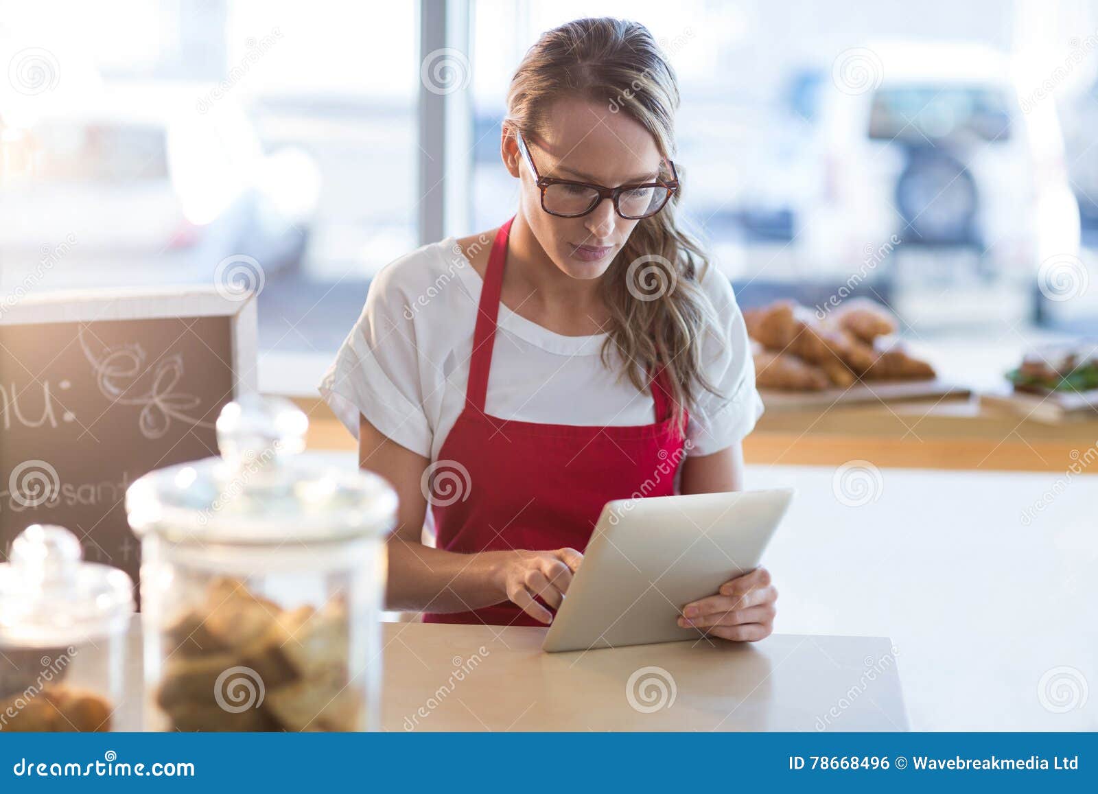 Waitress Sitting at Table and Using Digital Tablet Stock Photo - Image ...