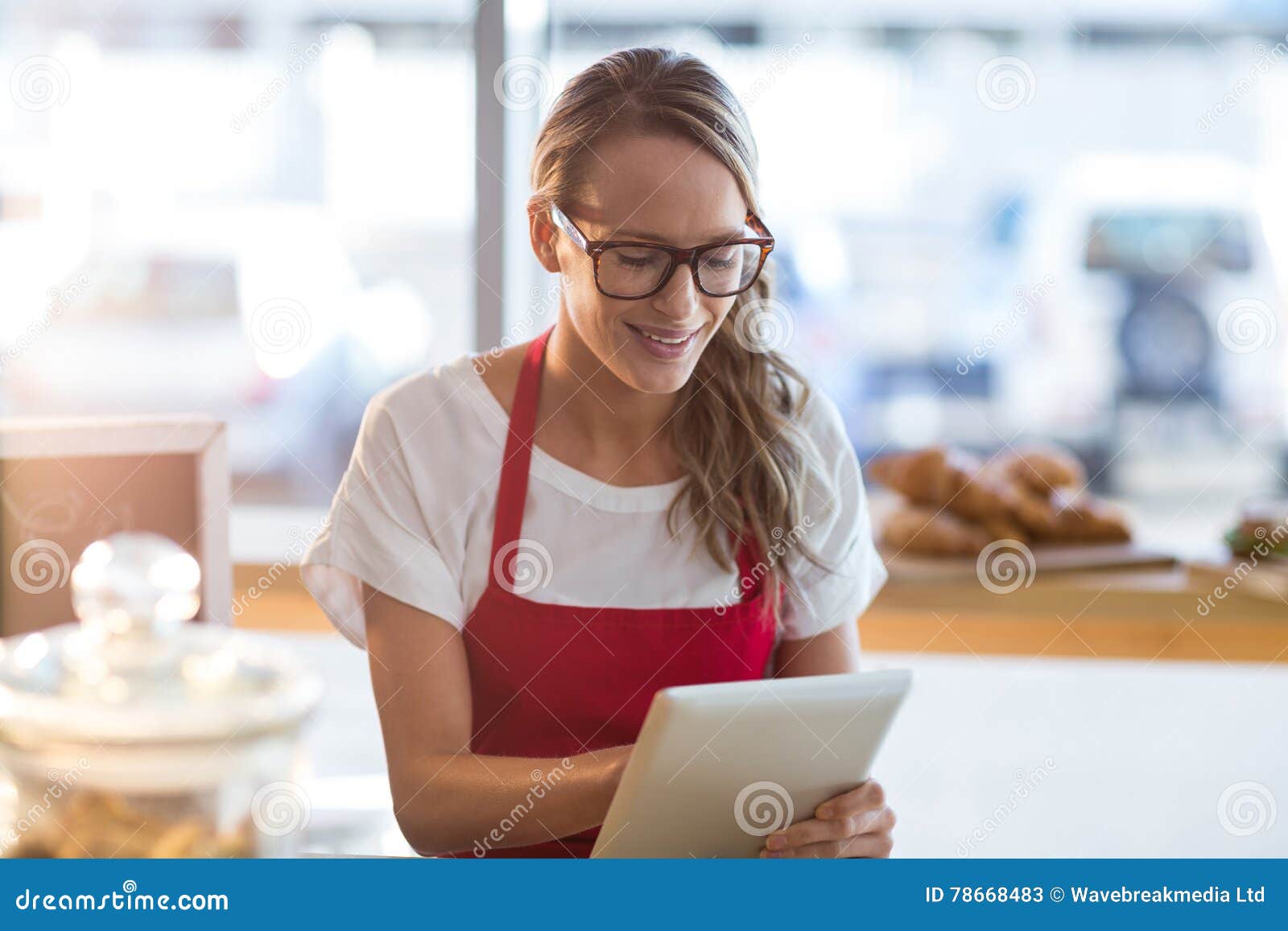 Waitress Sitting at Table and Using Digital Tablet in CafÃ© Stock Image ...