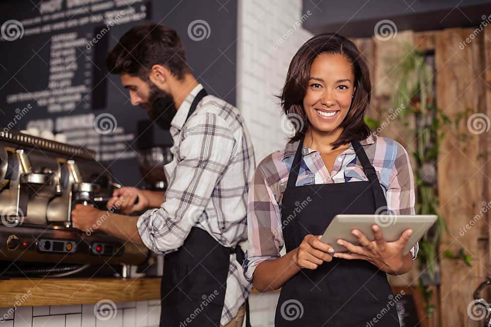 Waitress Using Digital Tablet while Waiter Preparing Coffee in ...
