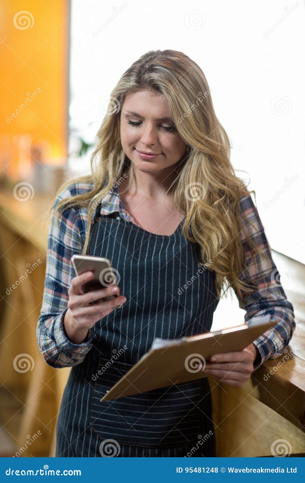 Waitress Using Mobile Phone at Counter Stock Photo - Image of checklist ...
