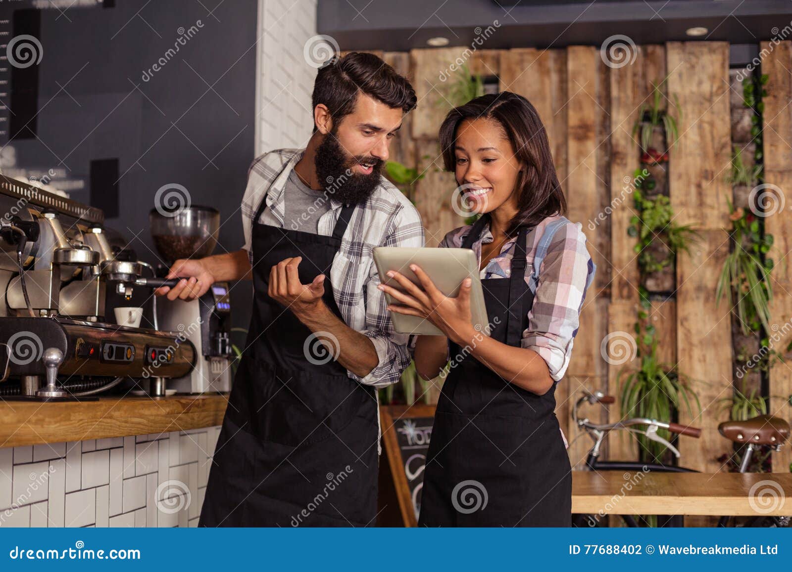 Waitress Using a Tablet Computer and Waiter with Coffee Machine Stock ...