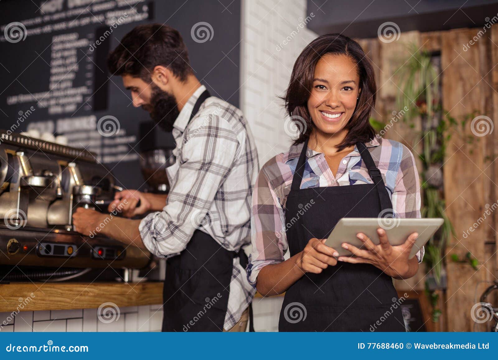 Waitress Using a Tablet Computer and Waiter with Coffee Machine Stock ...