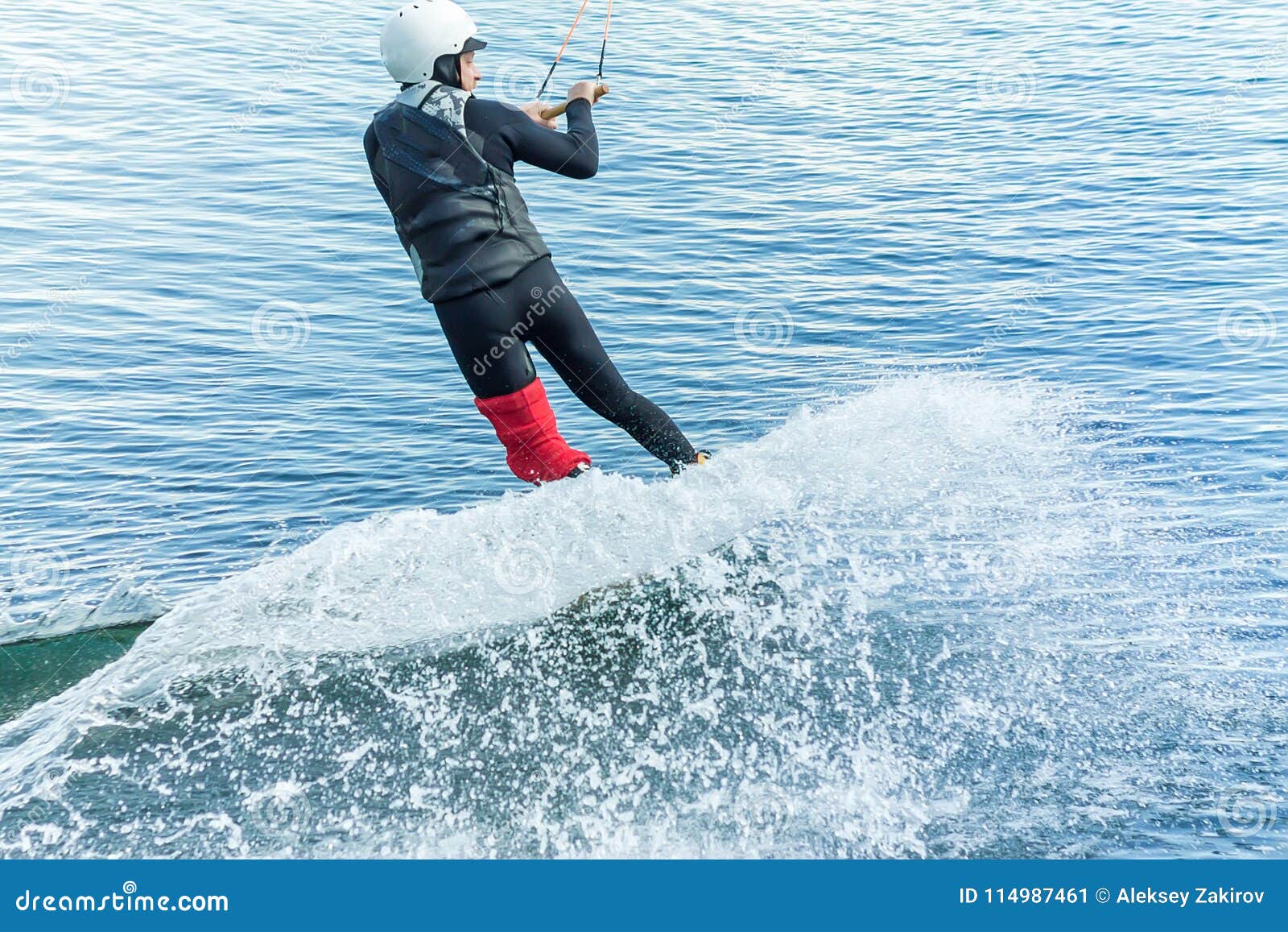 Wakeboarder Jumps from a Springboard Behind a Rope and Makes a Wave on ...