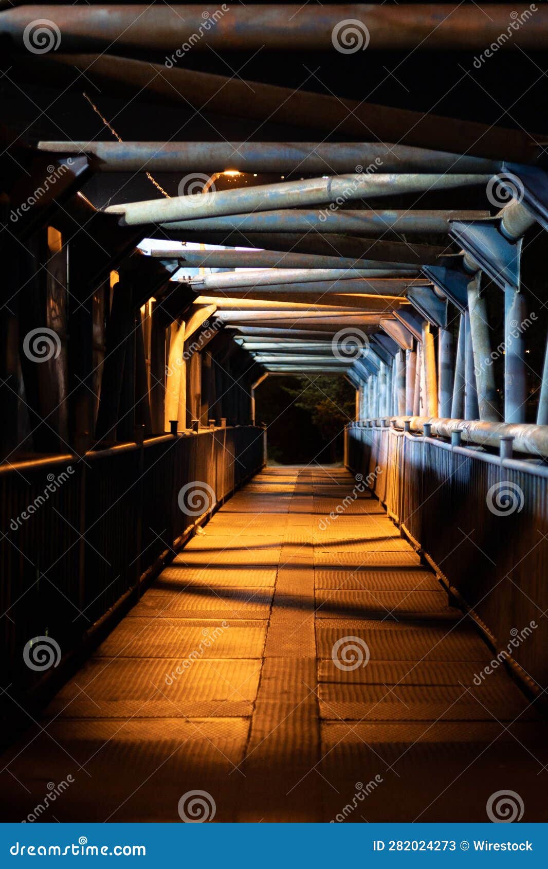 A Walkway at Night Under Some Bright Lights in a Dark Area Stock ...