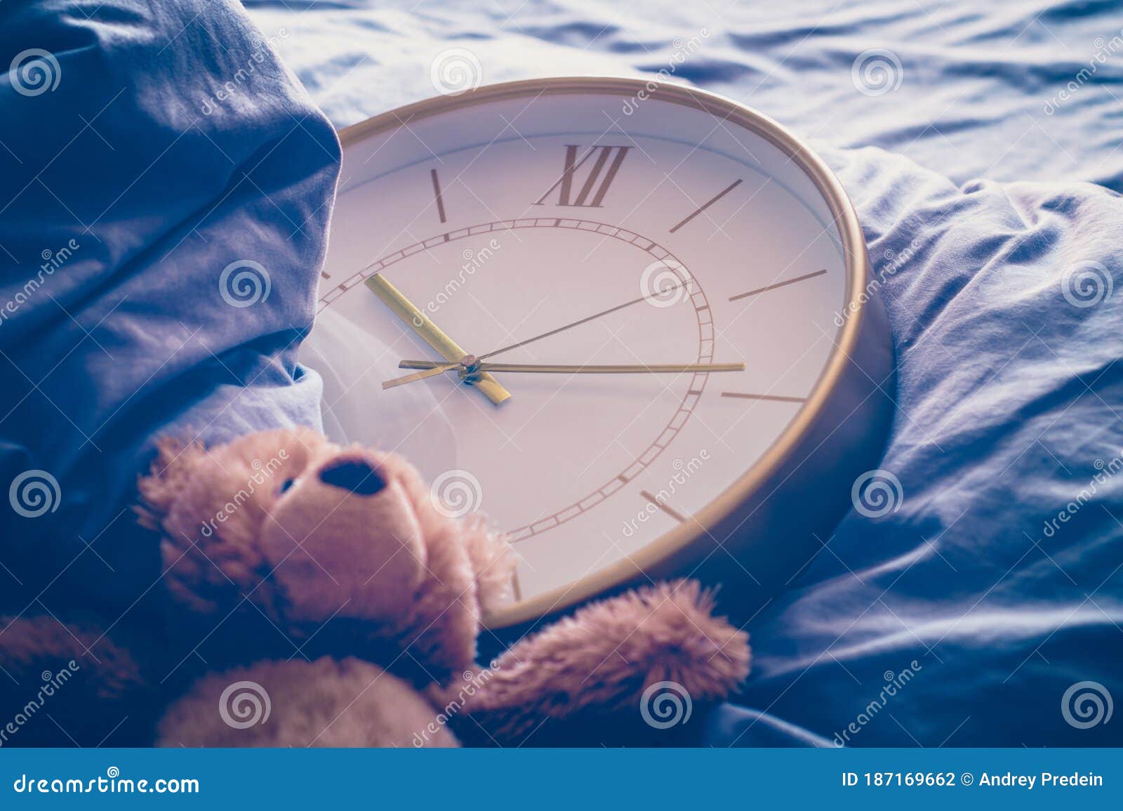 Clock in bed on a blanket stock photo. Image of bedtime - 187169662