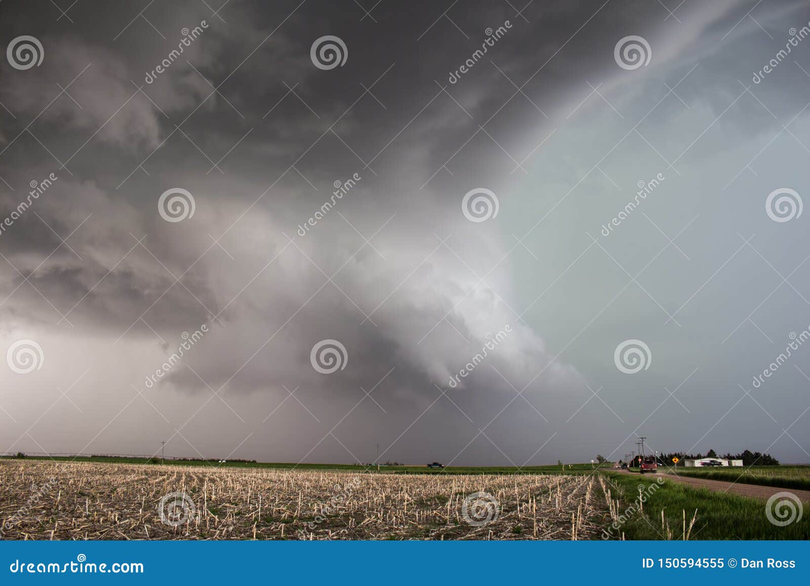 A Wall Cloud Gathers Under the Base of a Supercell Storm Over a Field ...