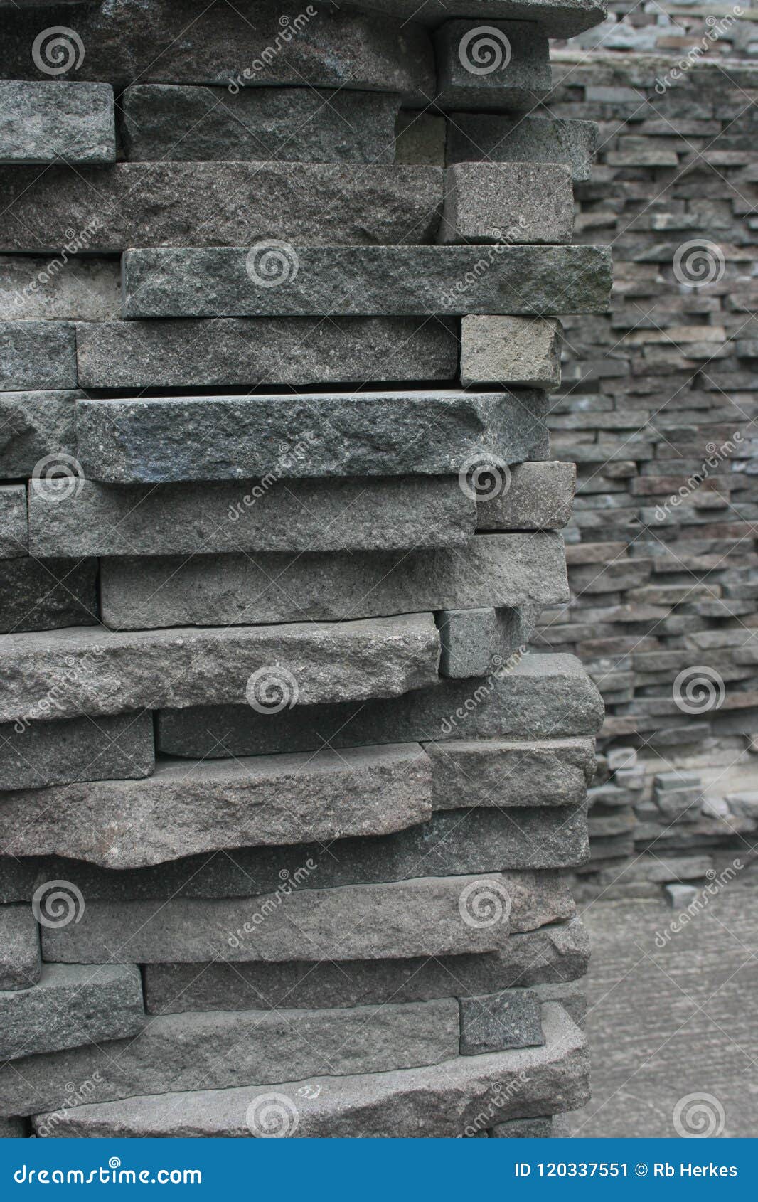 Wall of Layered Stones in a Rough Hewn Pattern with Wall in Background ...