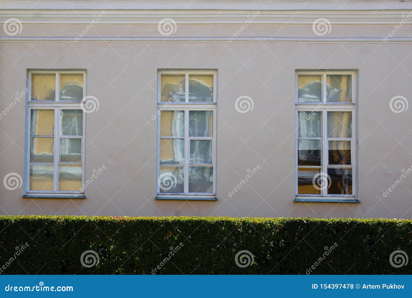 Wall with Three Windows on the Background of Green Bushes Editorial ...