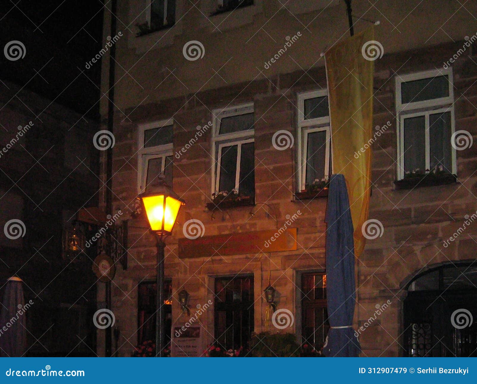 A Wall with Windows of an Ancient Building is Illuminated by Lanterns ...