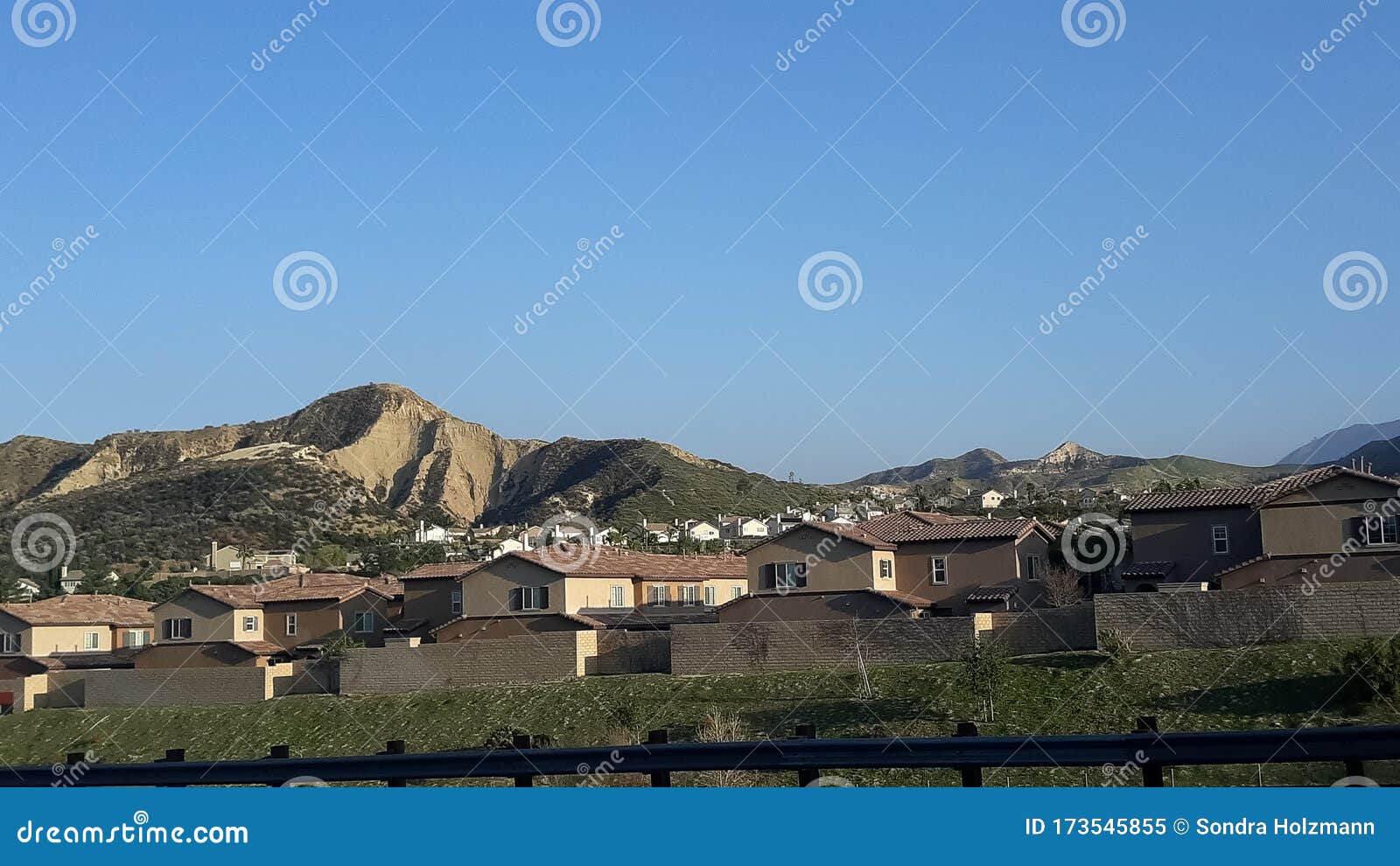 Walled Community with Mountains and Trees Under a Blue Sky Stock Image ...