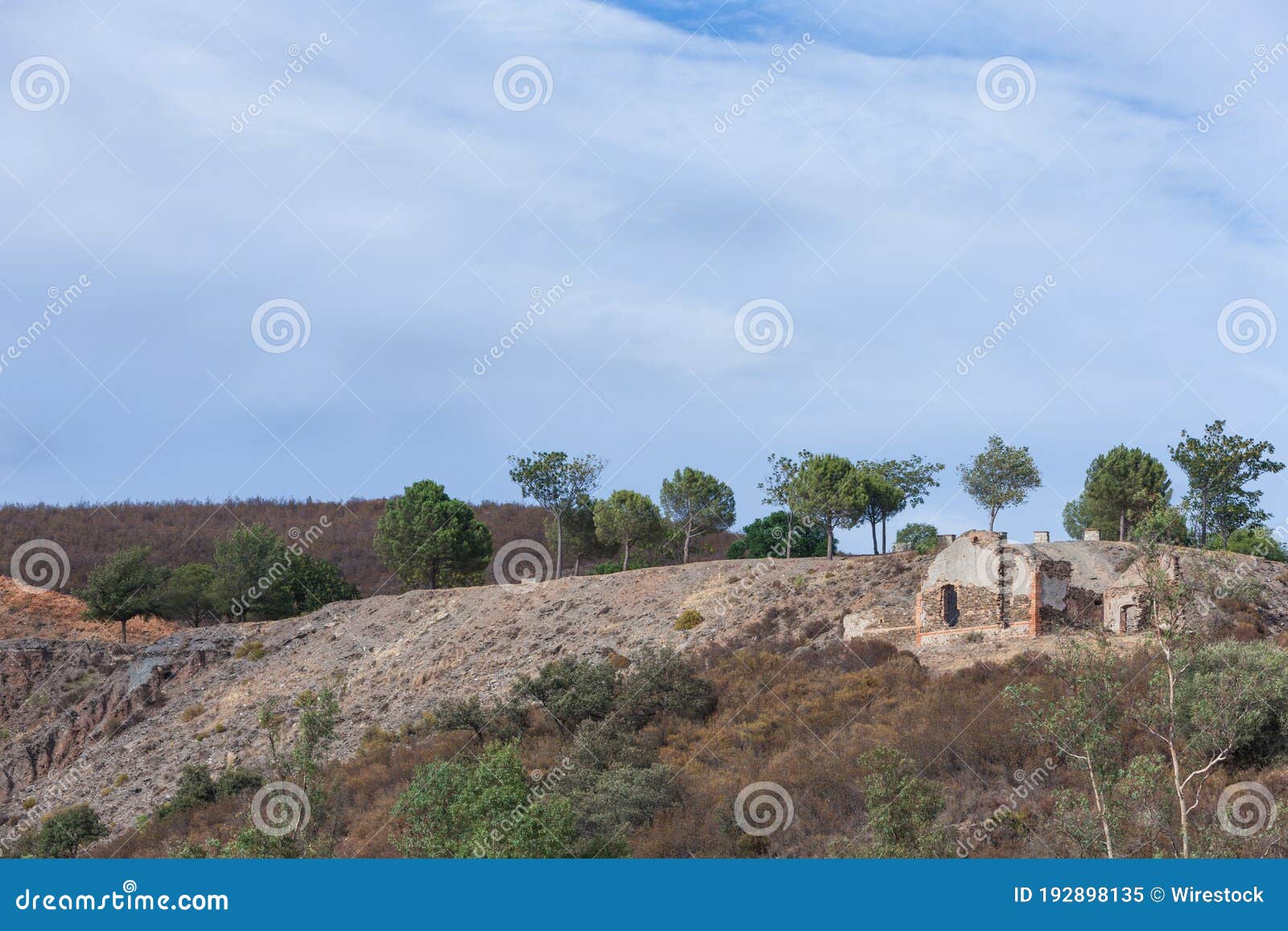 Walls of a Ruins on a Hill with Shrubs and Trees Under a Cloudy Blue ...