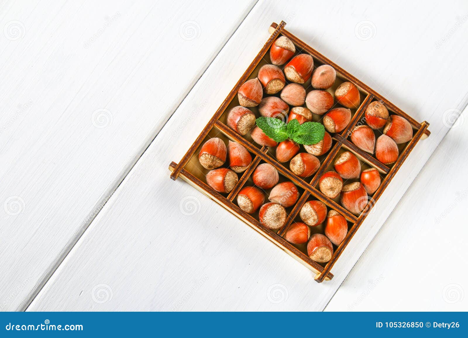 Walnut Hazelnuts in a Square Wooden Box with Dividers on a White Wooden ...