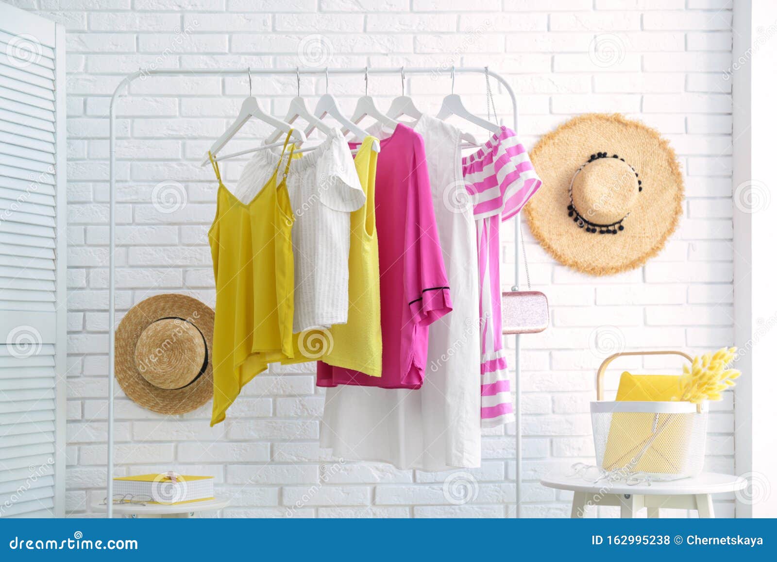Wardrobe Rack with Women`s Clothes at Brick Wall in Room Stock Photo ...