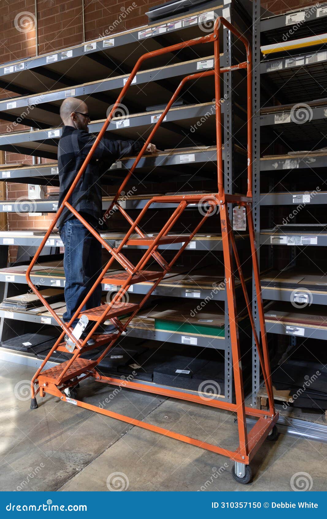 Warehouse Factory Working On A Ladder Pulling Product From The Racking ...