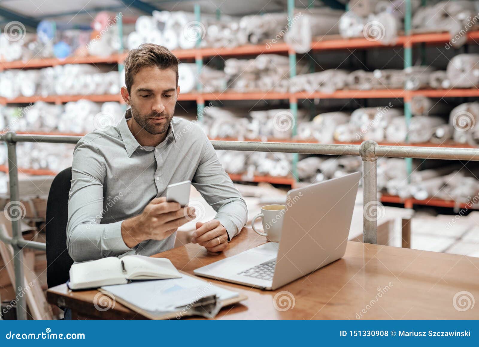 Warehouse Manager Checking His Cellphone while Working in His Office ...