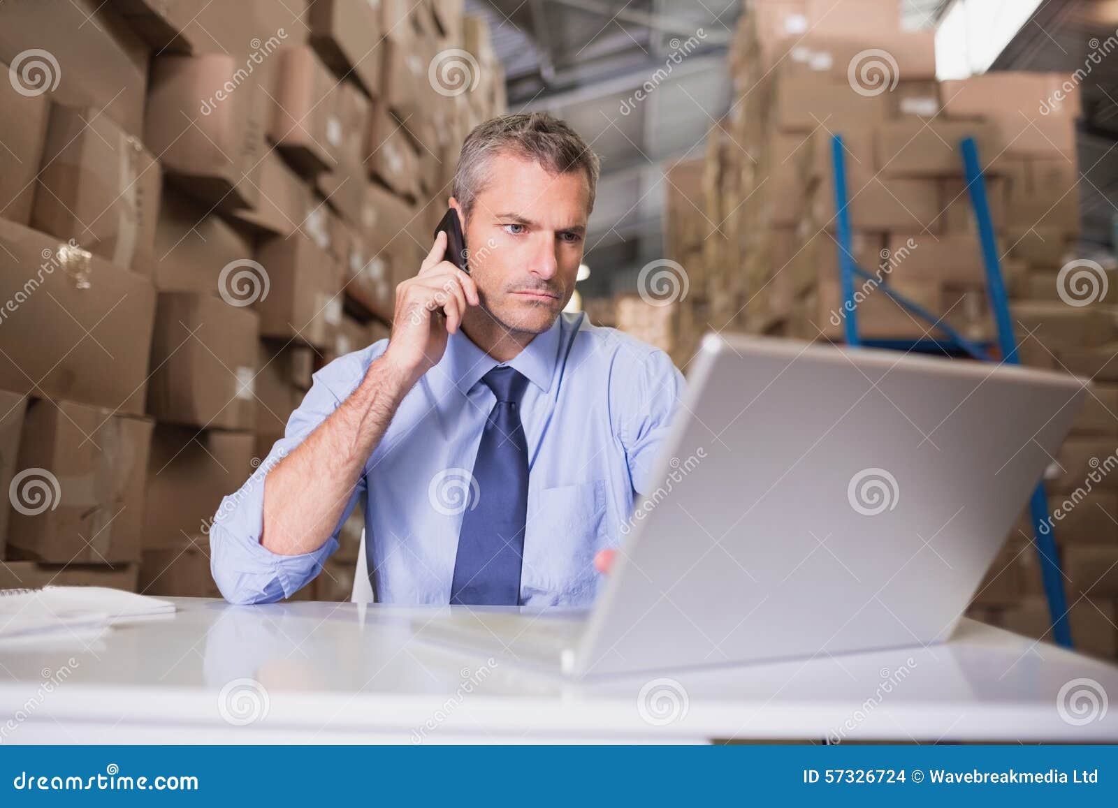 Warehouse Manager Using Cellphone and Laptop Stock Photo - Image of ...