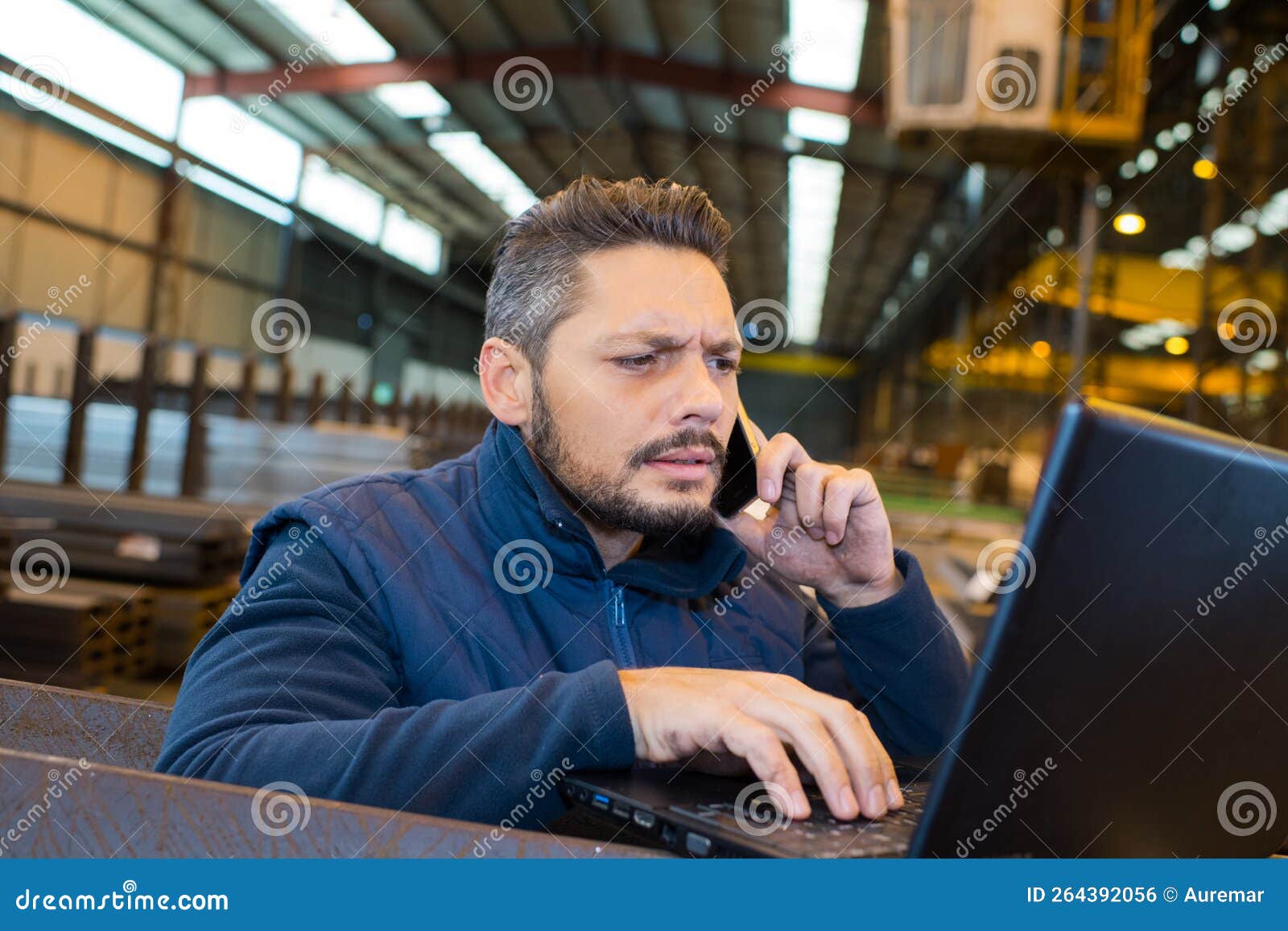 Warehouse Manager Using Telephone and Laptop in Large Warehouse Stock ...