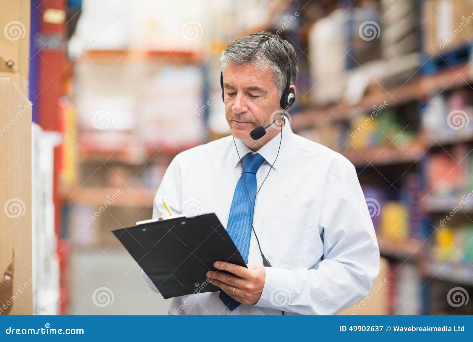 Warehouse Manager Wearing Headset Writing on Clipboard Stock Image ...