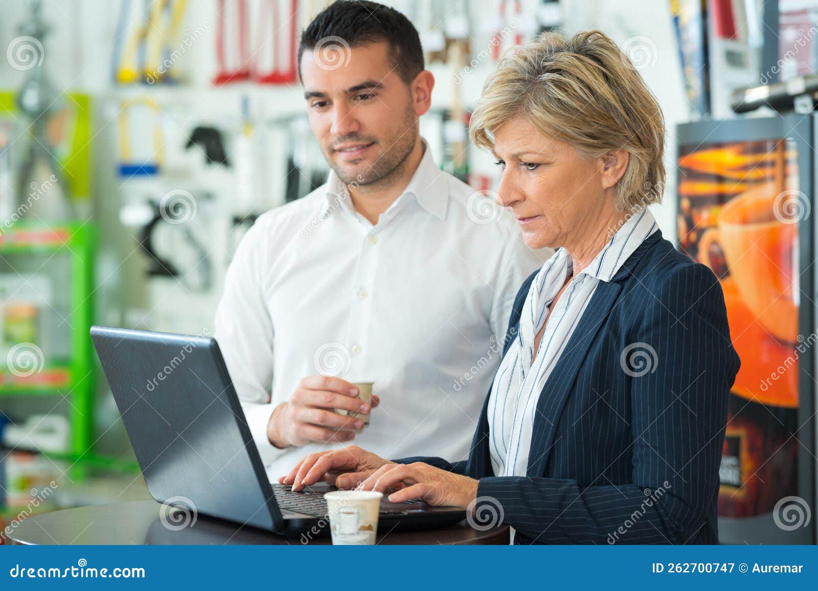 Warehouse Managers Working Together on Laptop in Large Warehouse Stock ...