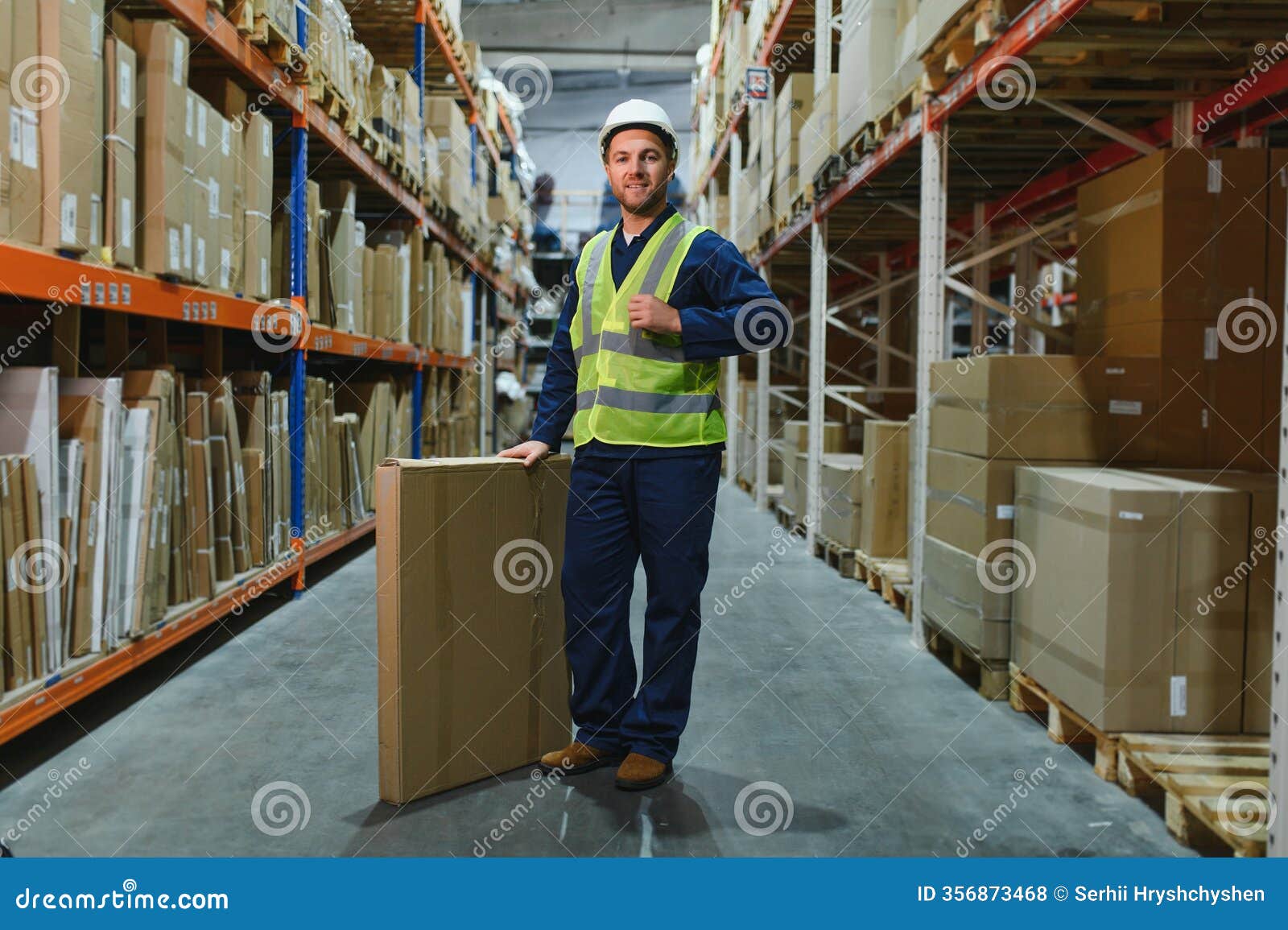 Warehouse Worker in Blue Uniform Holding a Large Cardboard Box. Stacks ...