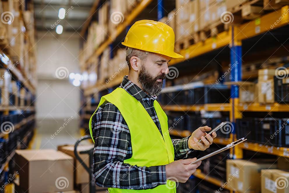 Warehouse Worker Checking Up Stuff in a Warehouse. Stock Image - Image ...