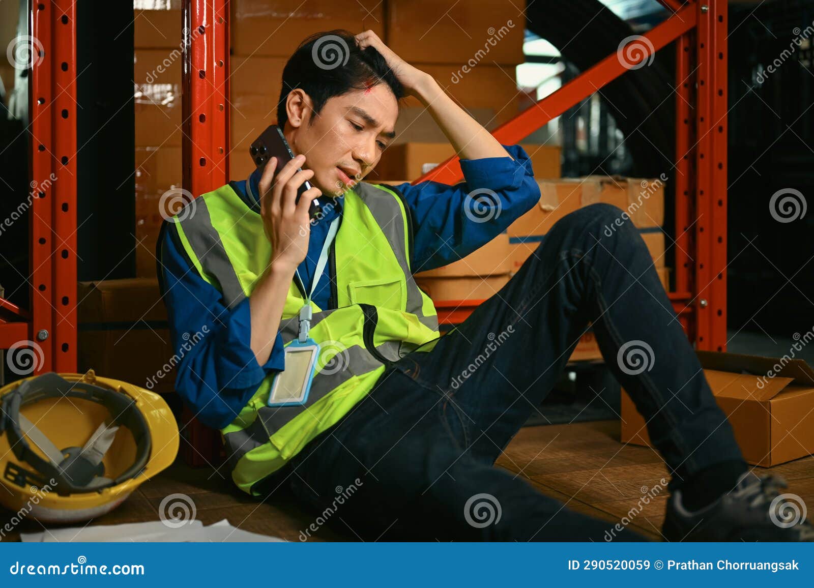 Warehouse Worker Making an Emergency Call, Asking for First Aid Team ...