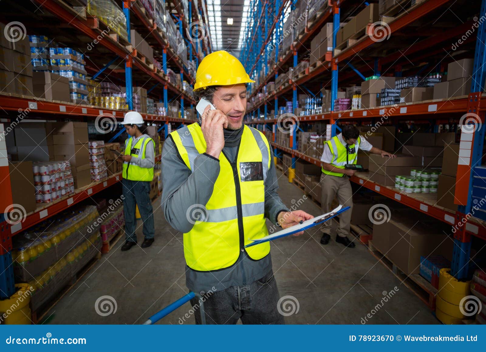 Warehouse Worker Talking on Mobile Phone and Holding Clipboard Stock ...