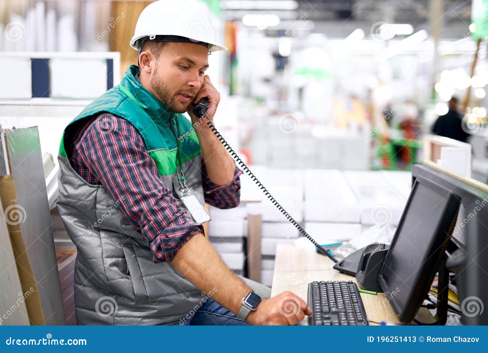 Warehouse Worker Talking on Phone at Desk in a Large Warehouse Stock ...