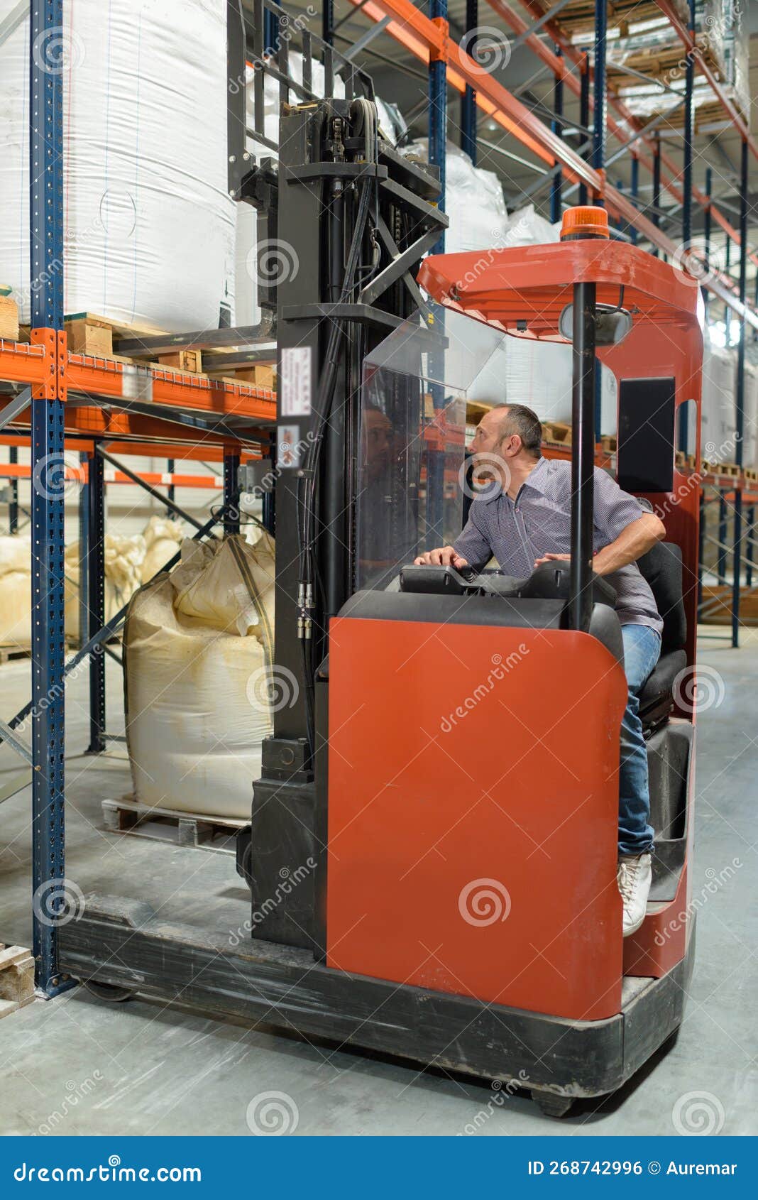 Warehouse Worker Using Fork Truck To Load Pallet on Racking Stock Photo ...